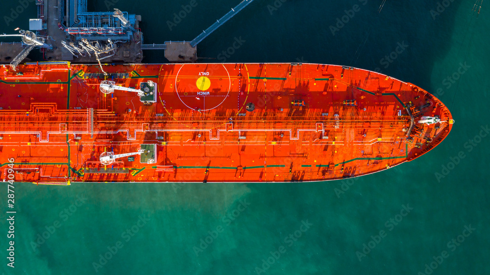 Red tanker ship loading and unloading oil and gas at industrial port ...