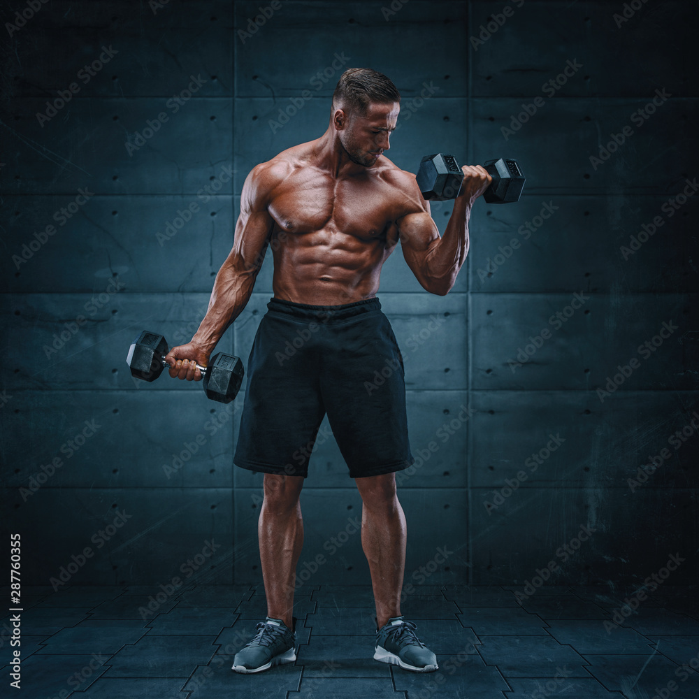Muscular Men Exercise With Weights. He is performing bicep curls with ...