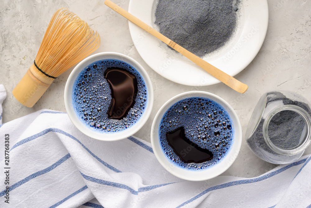 Blue matcha tea in two white cup , wooden tray, bamboo tavan and tasaku ...