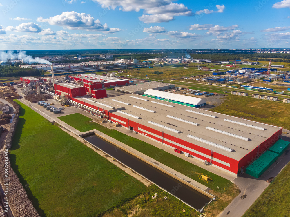 Wood processing plant pollutes the air with smoke coming from the pipe ...