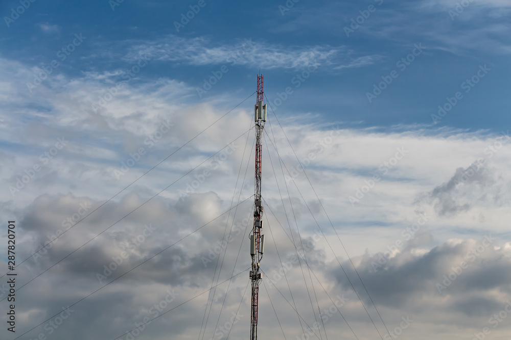 There is a gray and red Radio relay tower with group of different ...