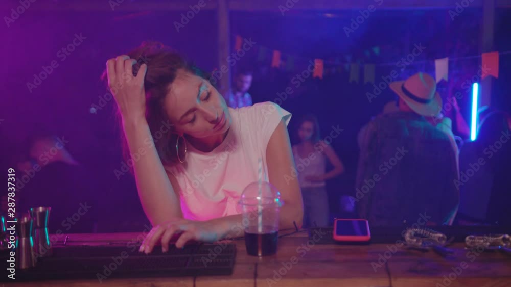 Beautiful lonely girl sitting alone at bar counter in the nightclub ...