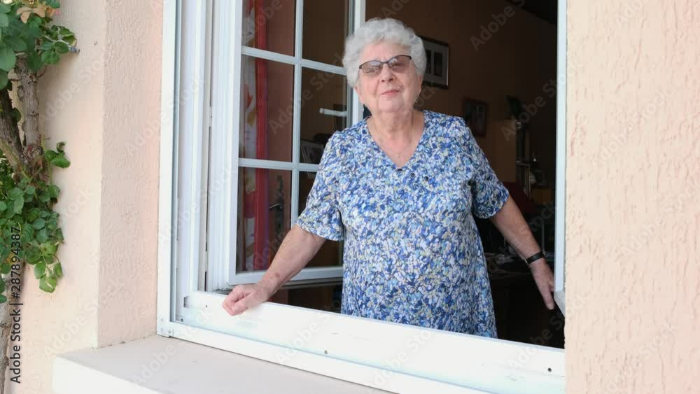 Vidéo Stock elderly senior woman opening a window of her house and ...