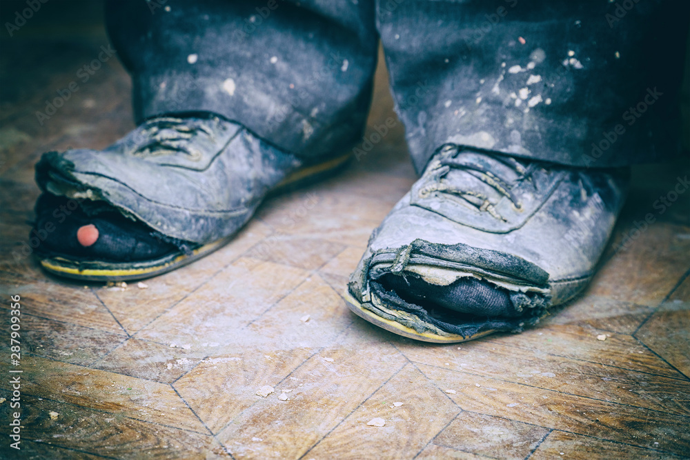 Old torn boots on the man's feet. Boots with holes. Selective focus ...