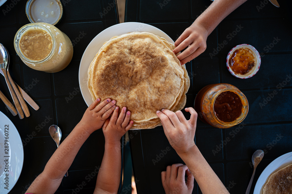 Kids reaching for crepes at breakfast Stock Photo | Adobe Stock