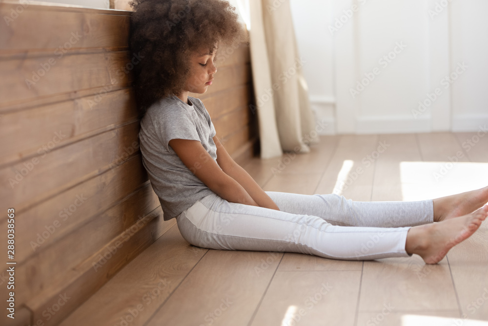 Upset black cute kid girl sitting alone on floor. Stock Photo | Adobe Stock