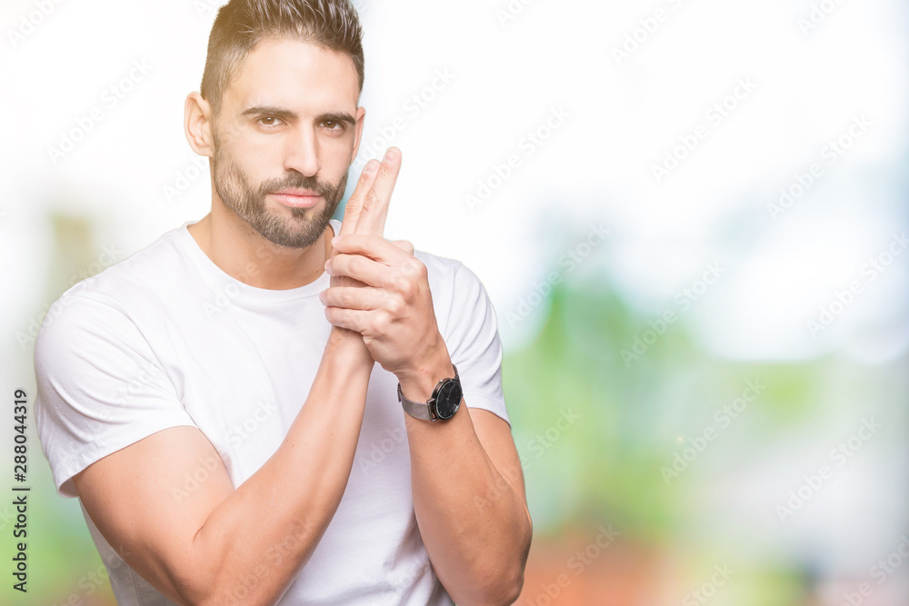 Handsome man wearing white t-shirt over outdoors background Holding ...