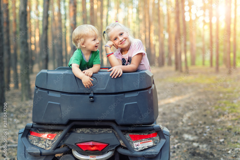 Cute adorable caucasian blond siblings having fun during atv 4x4 off ...