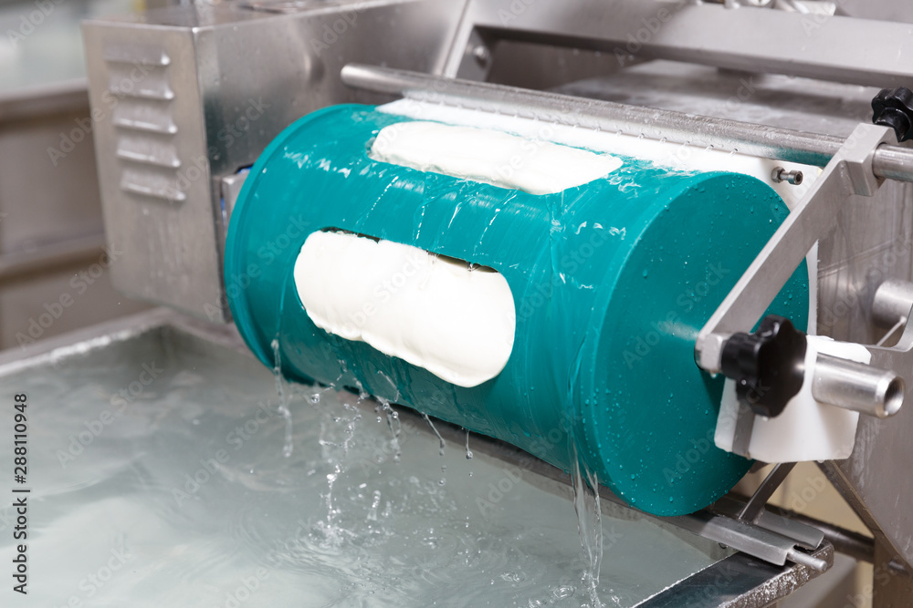 Fresh and hot mozzarella cheese put in a form before cooling bath on a ...