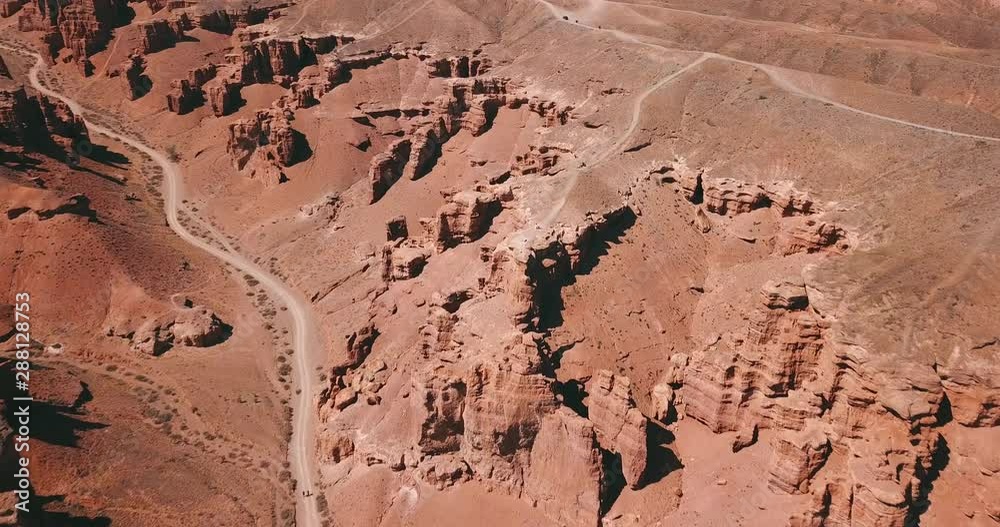 Big Charyn canyon and a young couple in white. Red rocks of different ...