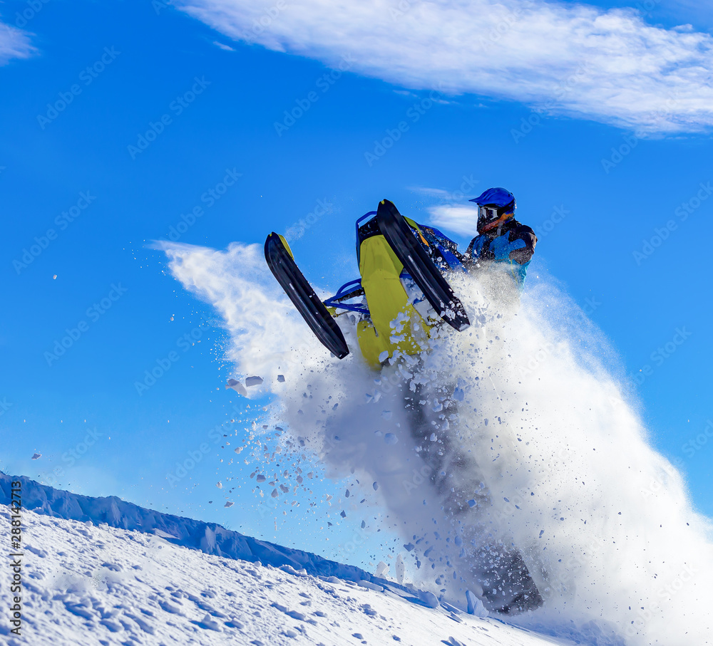 snowmobile jump. bright snowmobile in motion. the guy is flying on a ...