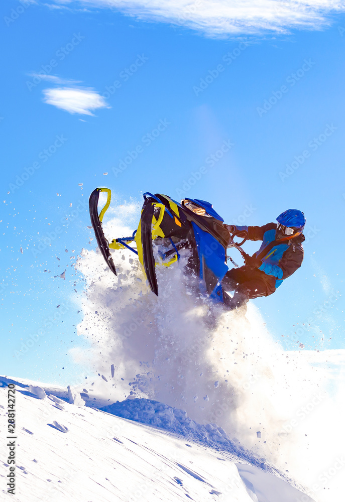 snowmobile jump. bright snowmobile in motion. the guy is flying on a ...