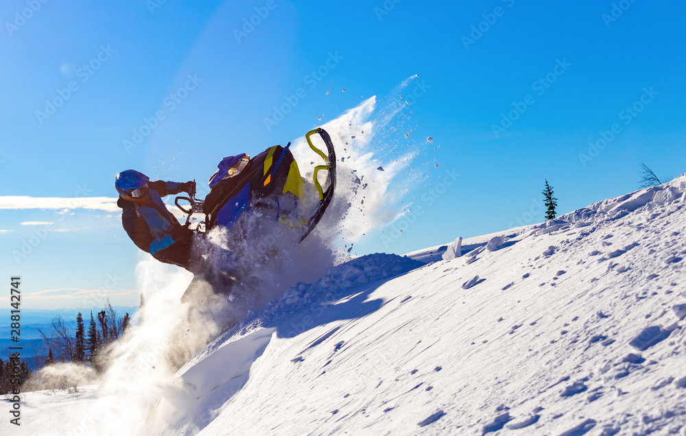 snowmobile jump. bright snowmobile in motion. the guy is flying on a ...