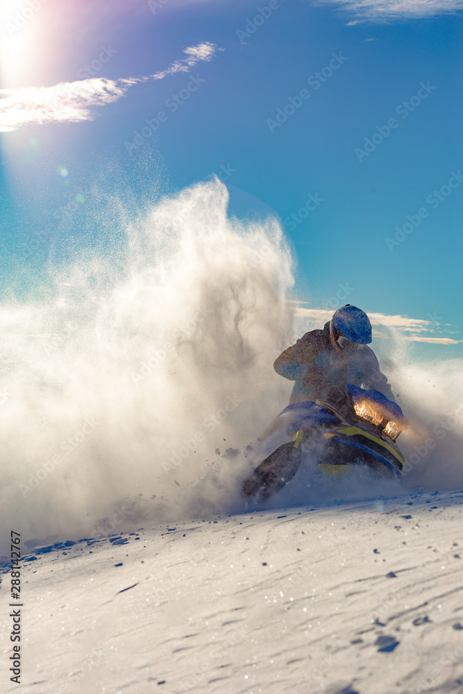 Snowmobile after jumping in the tubers of snow dust. snowmobile in a ...