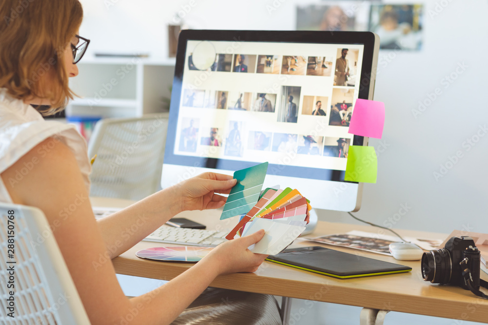 Graphic designer checks the color with color swatch at desk Stock Photo ...