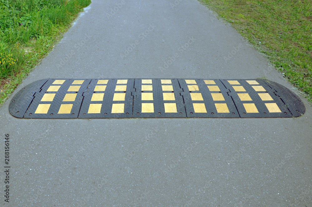 Speed bump on an asphalt road in an area of individual residential ...