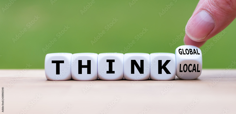 Foto de Hand turns a dice and changes the expression "think local" to ...