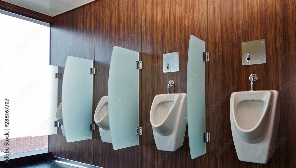 Weiße Urinale an Holzwand in Herrentoilette auf Kreuzfahrtschiff ...