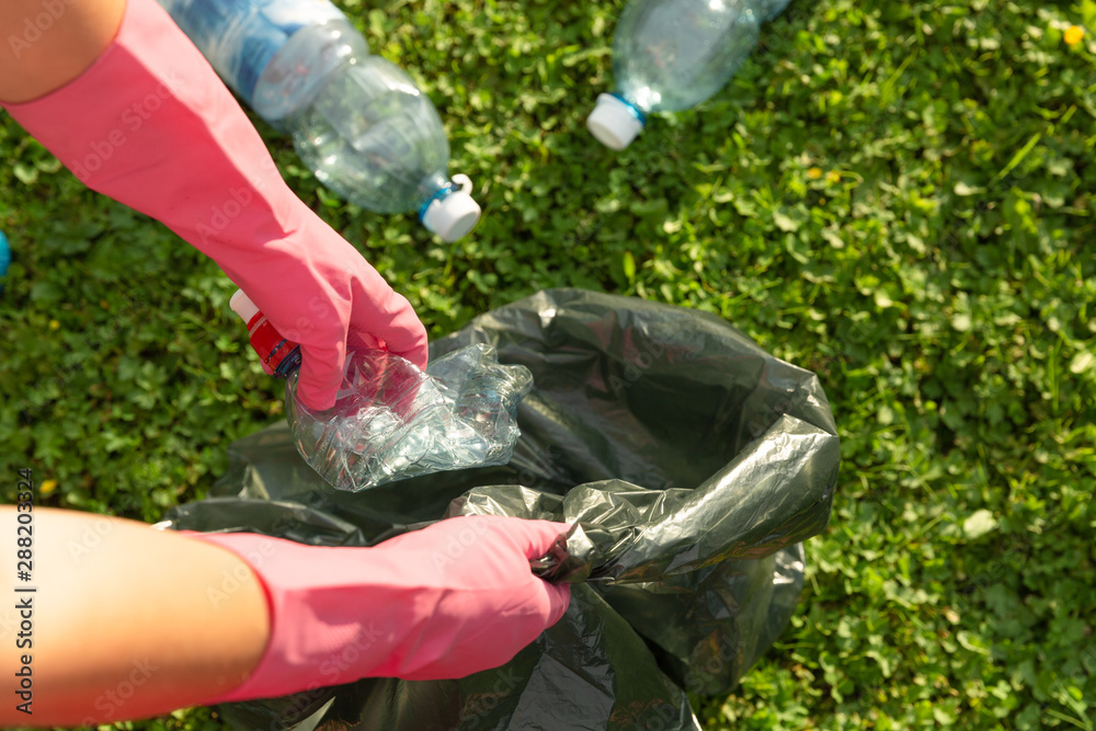 Young volunteer with garbage bag picking up trash outdoor, cleaning ...