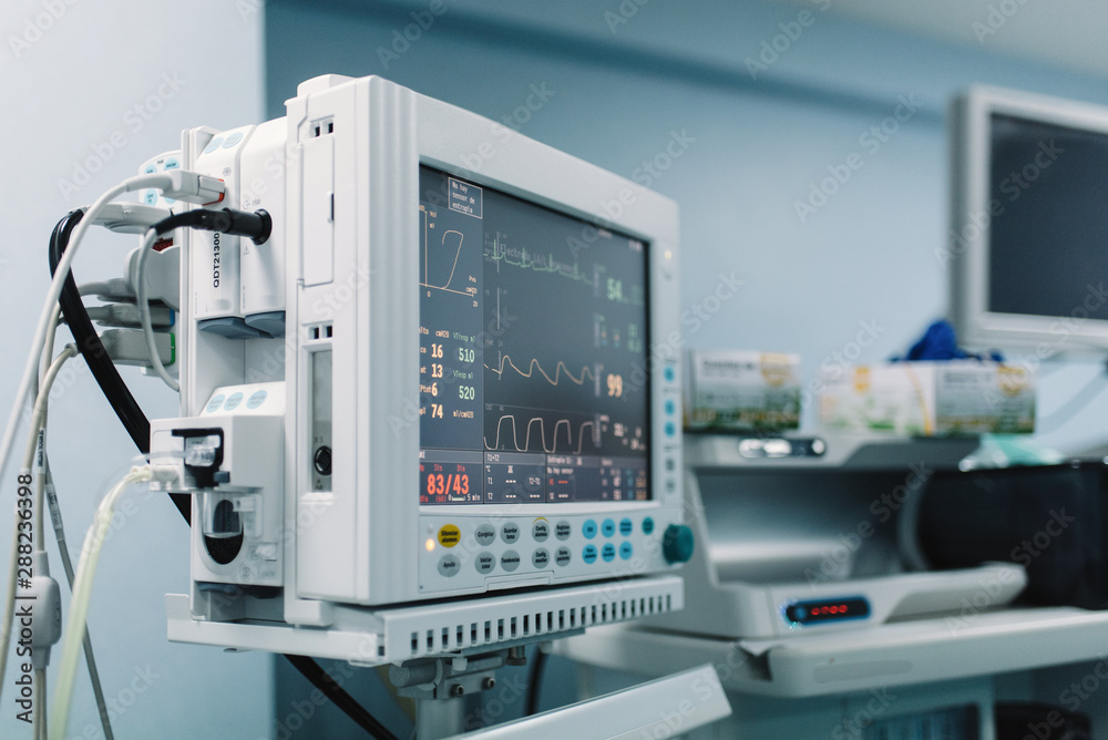 Medical equipment with screens showing vital signs of patient in ...