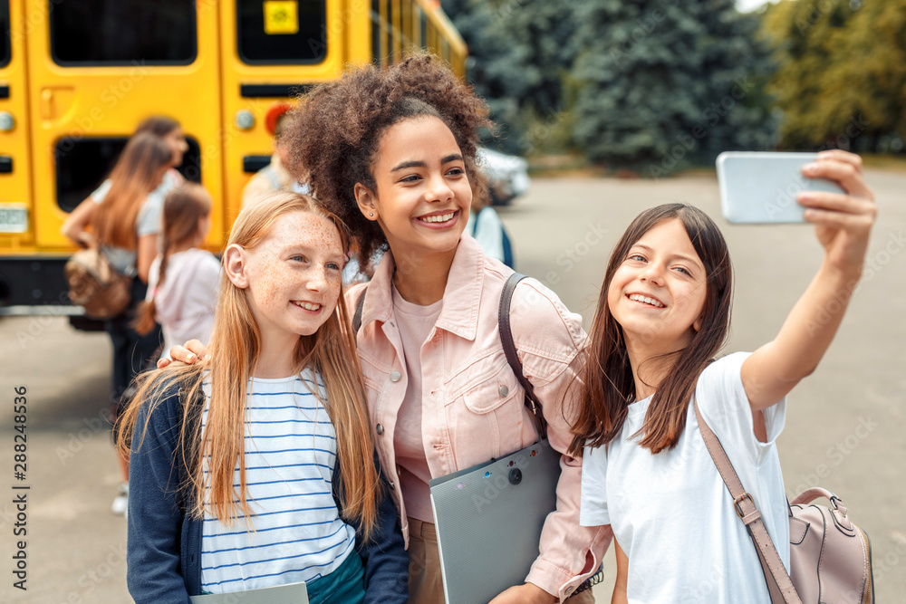 First Day. Classmates going to school by bus girls standing close-up ...