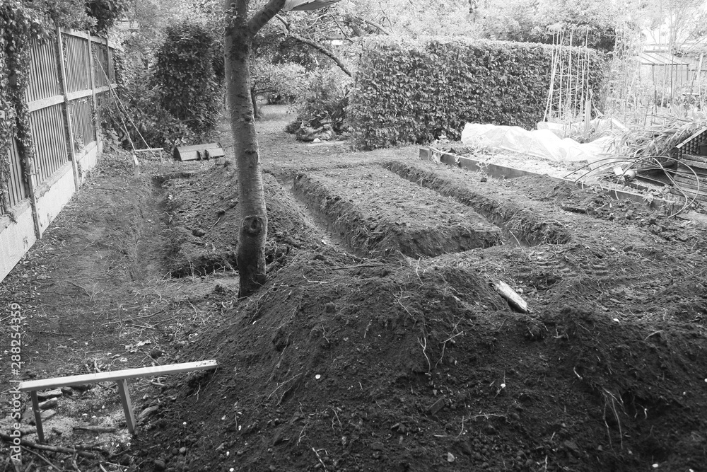 Landscape view of trenches dug for foundations of garden hut or studio ...