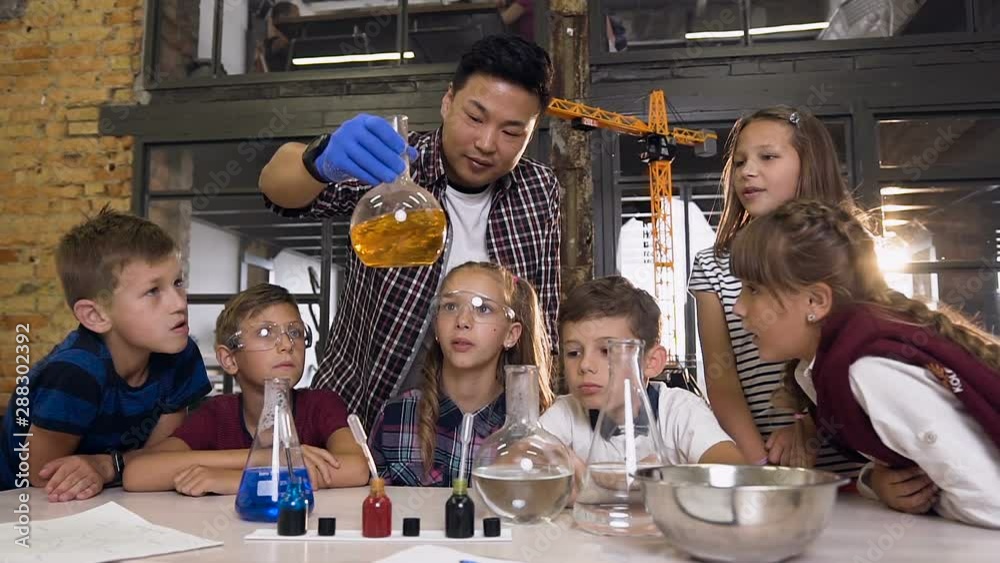 Scientist showing kids how to do chemical reaction experiments in lab ...