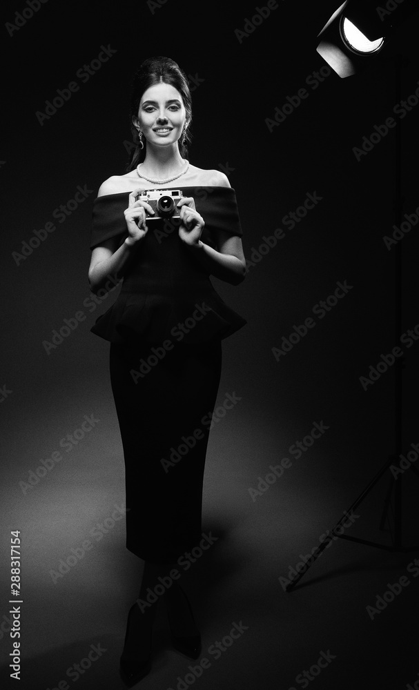 Retro shot: beautiful young woman shooting by old film camera. Vintage ...