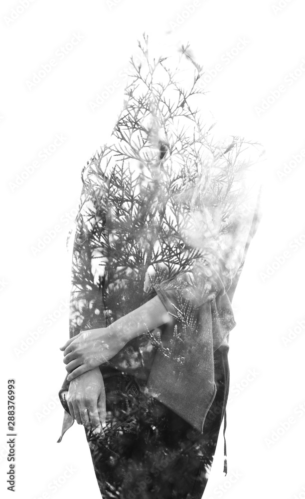 Double exposure of a young long haired woman blended with branches and ...