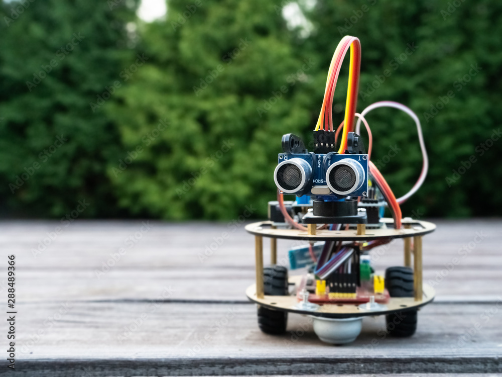 Hand made robot working on the electronic platform. Natural background ...