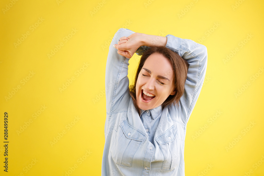 Beautiful young female charmingly smiling with her arms thrown back ...