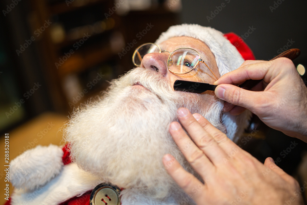 Foto de Santa Claus shaving in barbershop. Looking in the mirror ...