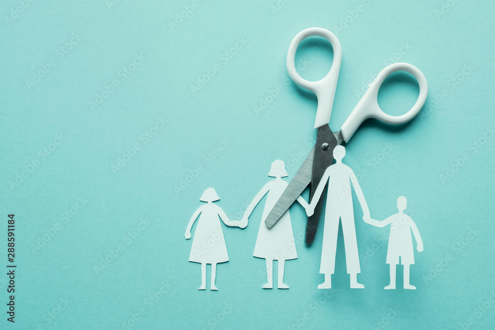 White scissor cutting family paper cut out on blue background, causes ...