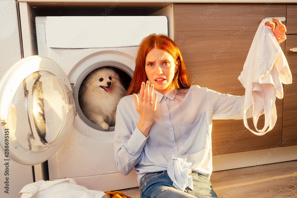 Fie, what stench! Shocked excited redhaired girl wash pile of dirty ...