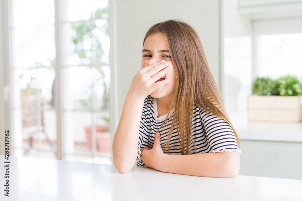 Beautiful young girl kid wearing stripes t-shirt smelling something ...