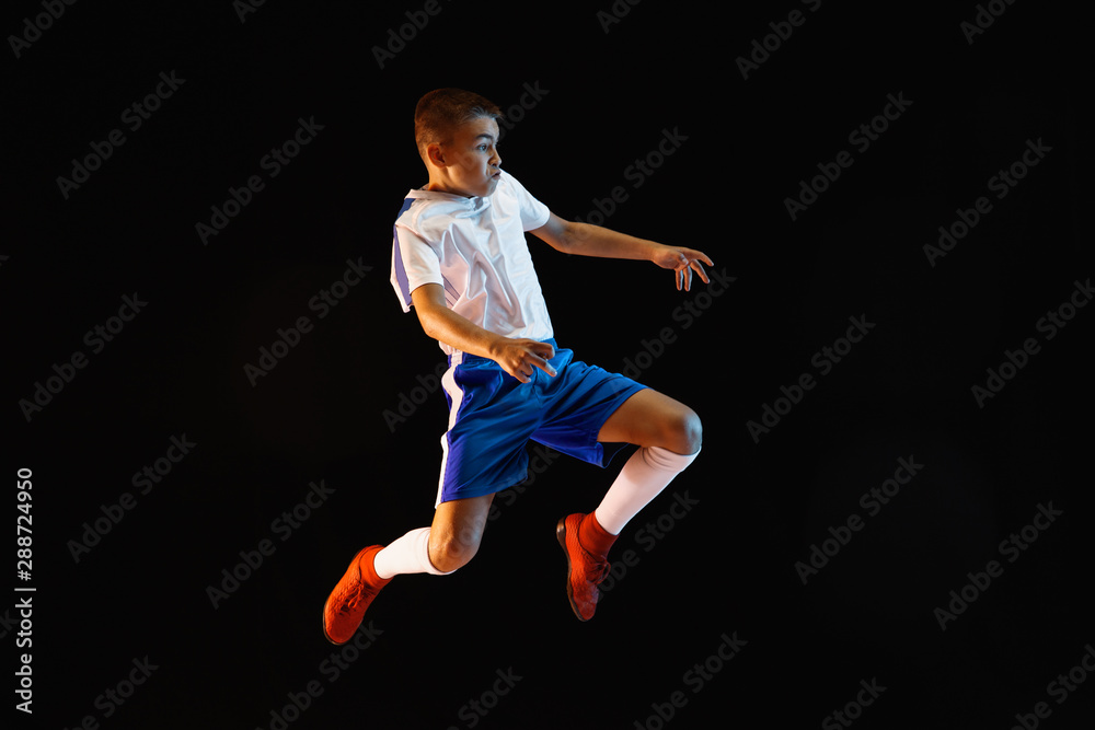 Young boy as a soccer or football player in sportwear making a feint or ...