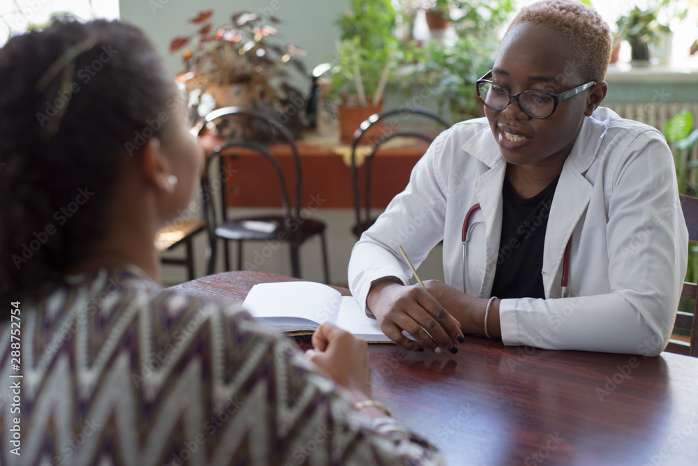 dark-skinned girl, doctor, takes a Latino patient. Doctor and patient ...