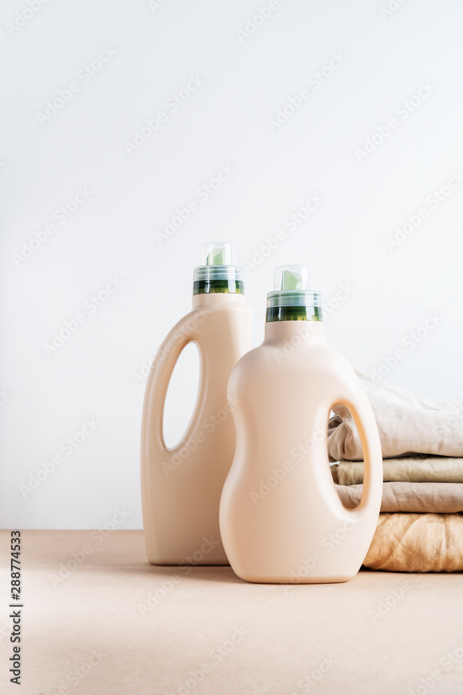 Pile of folded clean clothes with Eco Design bottles packaging for mock ...