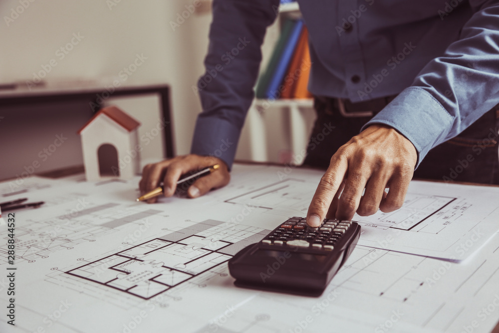 Architect Engineer using calculator Estimate construction drawings with ...