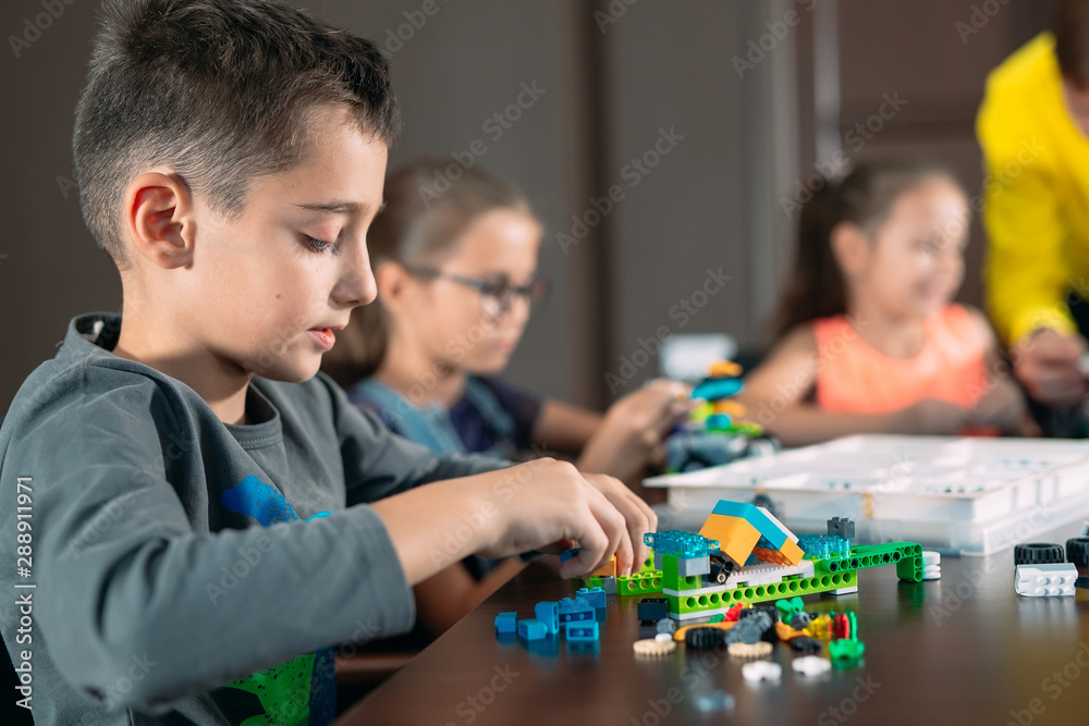 Kids creating robots with teacher. Early development, diy, innovation ...