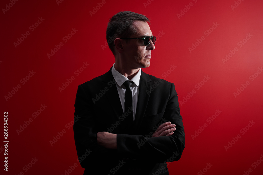 Portrait of strict serious adult man in suit and black glasses looks ...