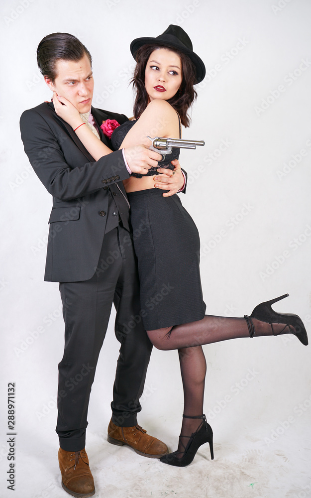 man in classic costume with gun protect his girlfriend on white studio ...