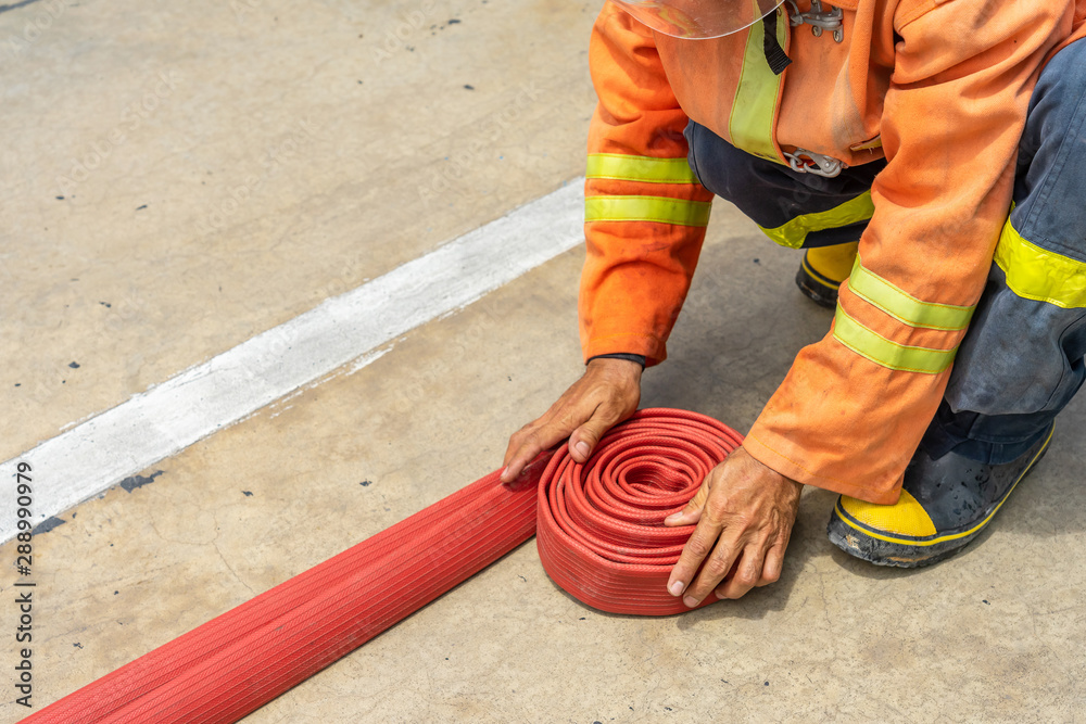 Rolled into a roll red fire hose, Fire equipment extinguishers ready to ...