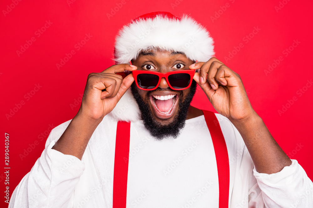 Close up photo of astonished african santa claus touching his specs ...