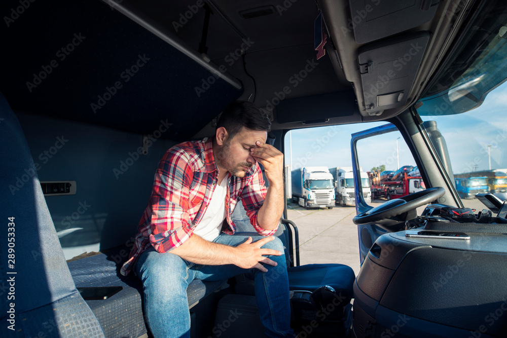 Truck driver sitting in his truck cabin feeling worried and upset ...