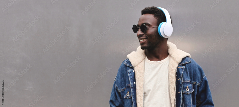 Portrait happy smiling african man in wireless headphones listening to ...