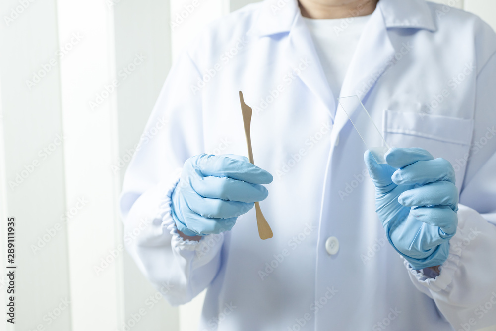 Foto de Doctor hand holding spatula and glass slide cytology set ...