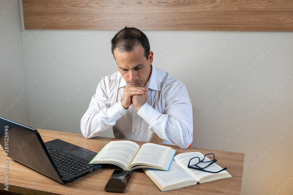 43 year old man concentrated on his books to make the report. Stock ...