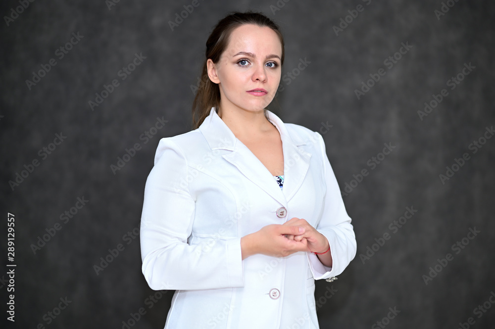 Business Portrait of a pretty female manager on a gray background in a ...