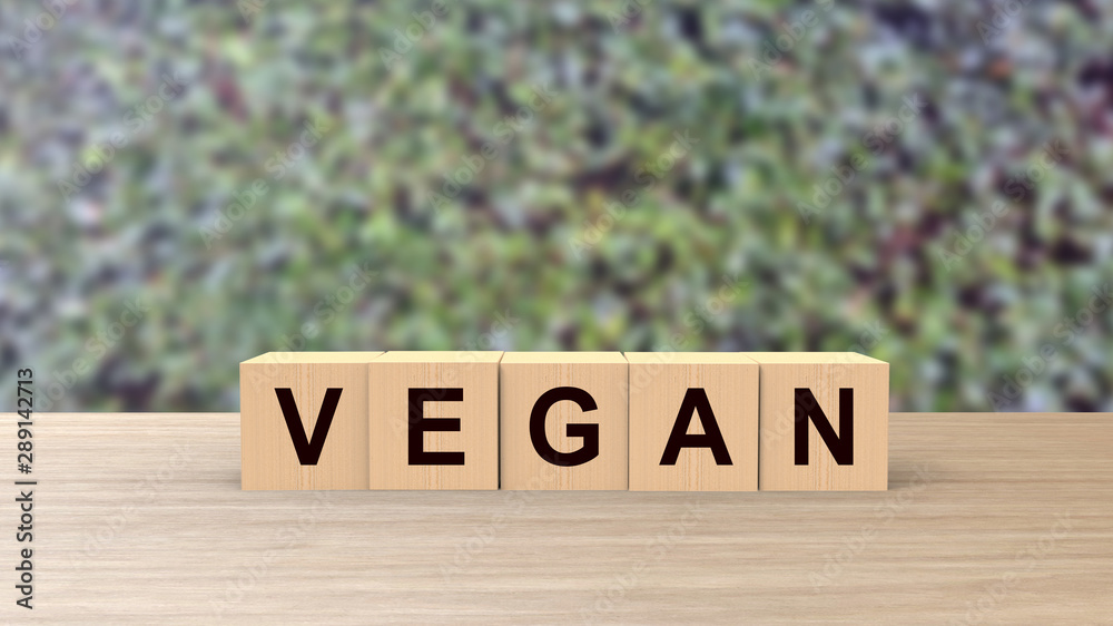 Vegan word wooden cubes on table vertical over blur background with ...